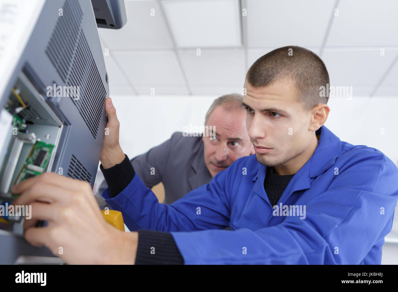 apprentice attempting to repair a computer Stock Photo - Alamy