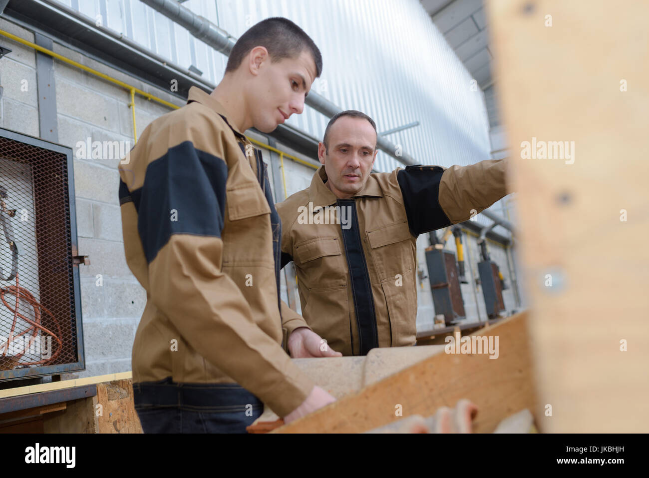 builder with young apprentice Stock Photo - Alamy