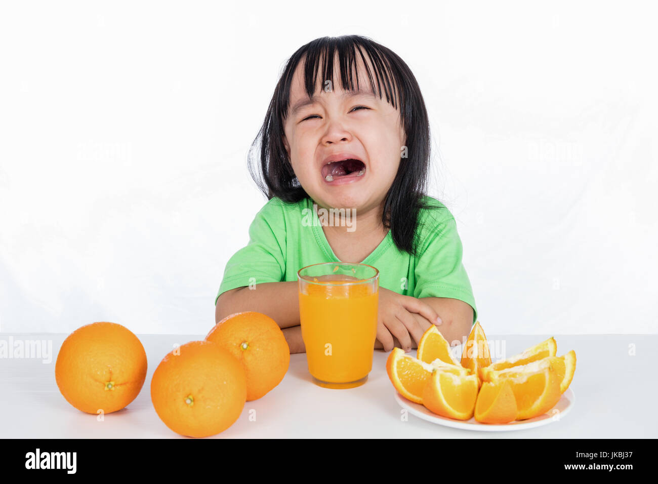 Asian Chinese little girl crying for orange juice in isolated white ...