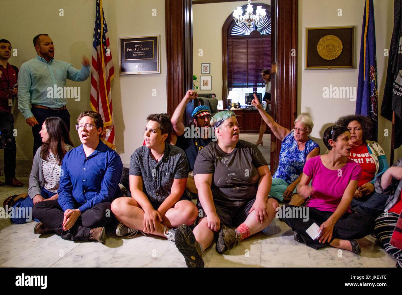 Demonstrators stage a sit-in outside the office of Senator Pat Toomey ...