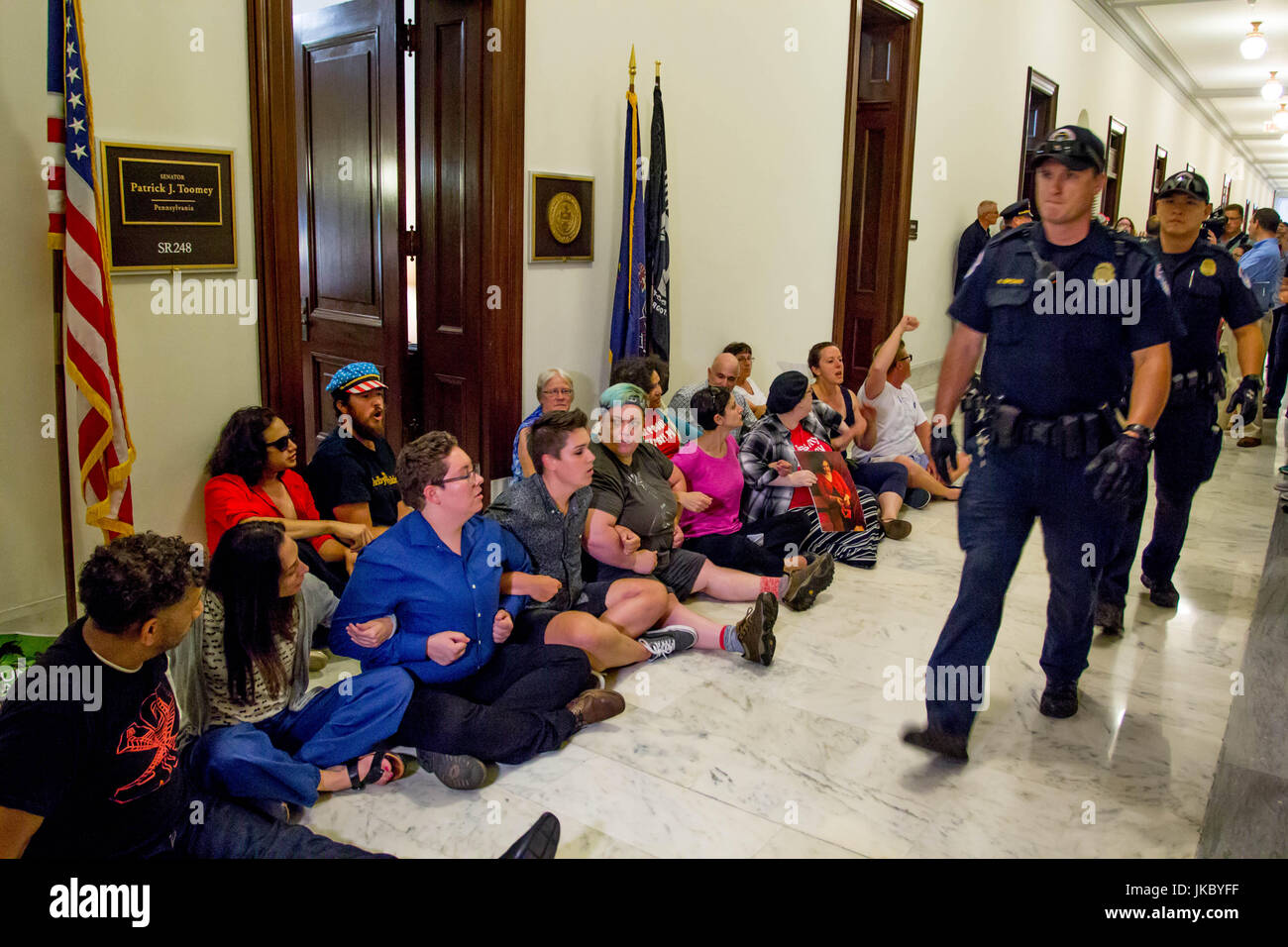 Demonstrators stage a sit-in outside the office of Senator Pat Toomey ...