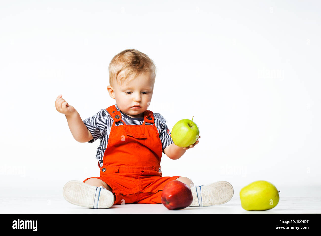 baby boy playing with green and red apples Stock Photo - Alamy