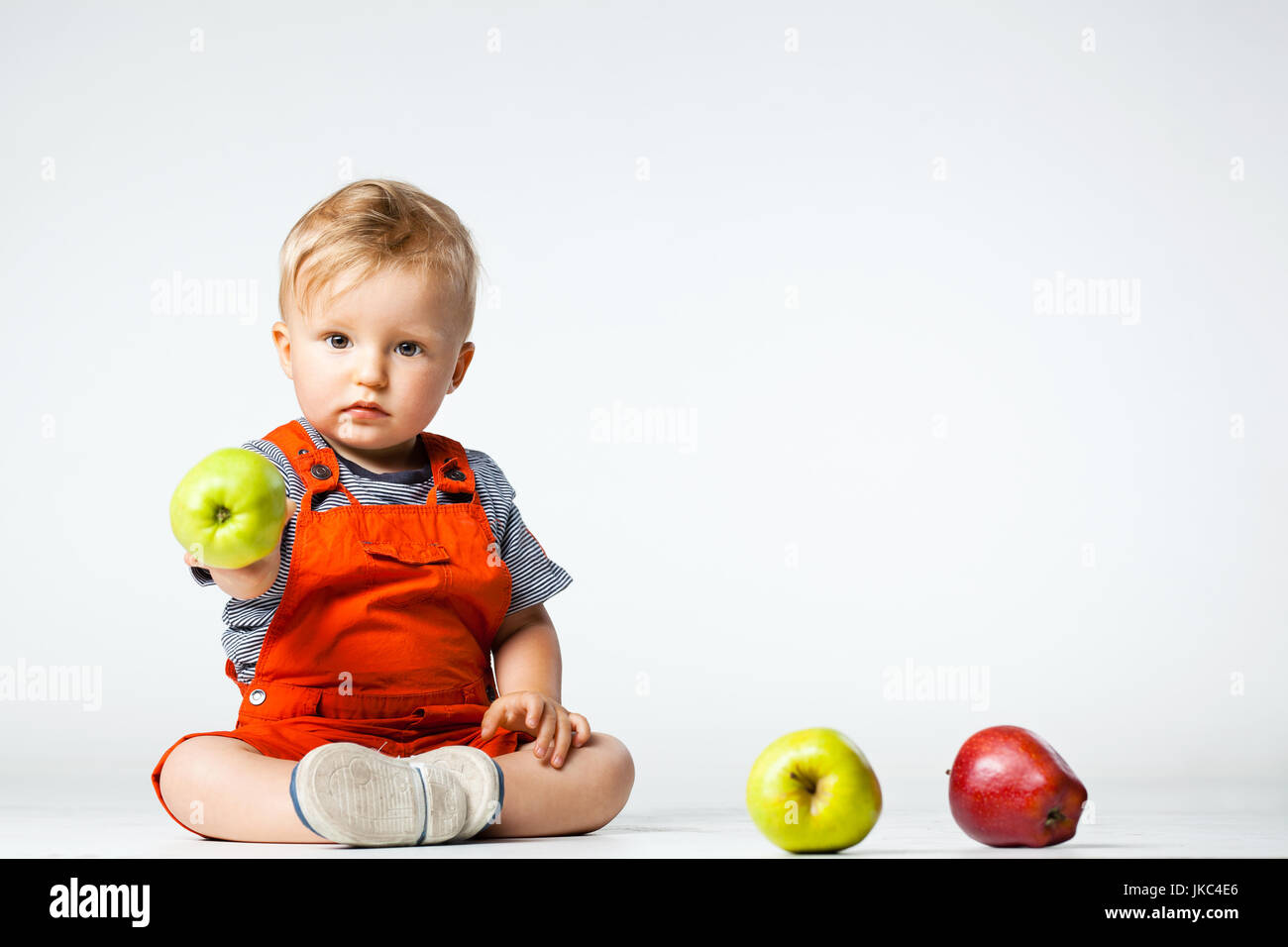 baby boy playing with green and red apples Stock Photo - Alamy