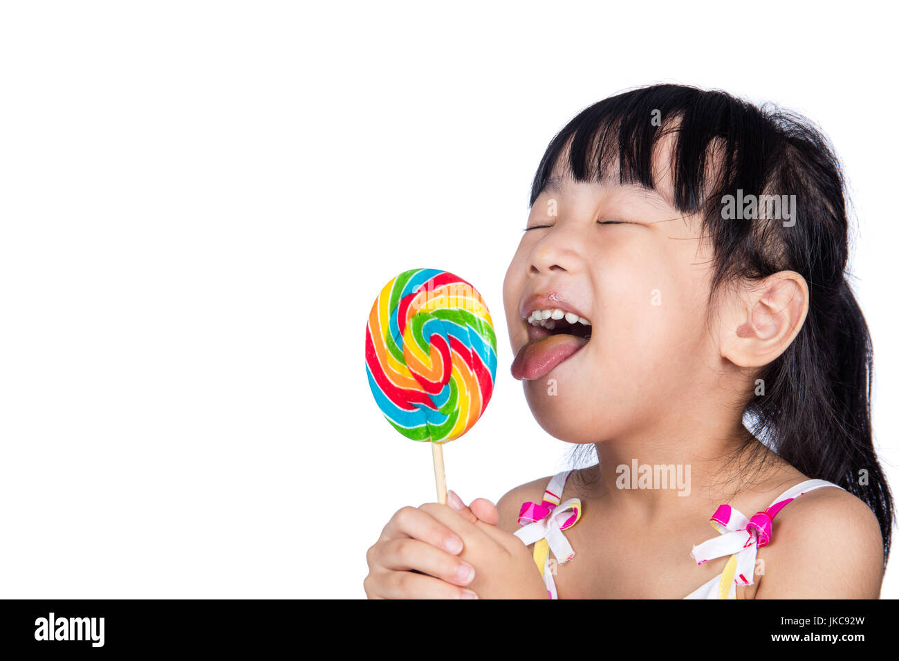 Asian Little Chinese girl eating lollipop in isolated white background ...