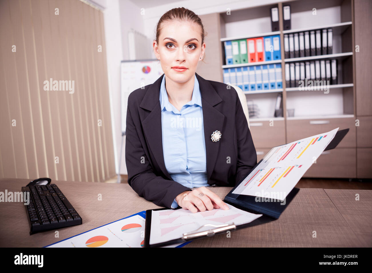 Woman in office with a chart folder in hands Stock Photo - Alamy