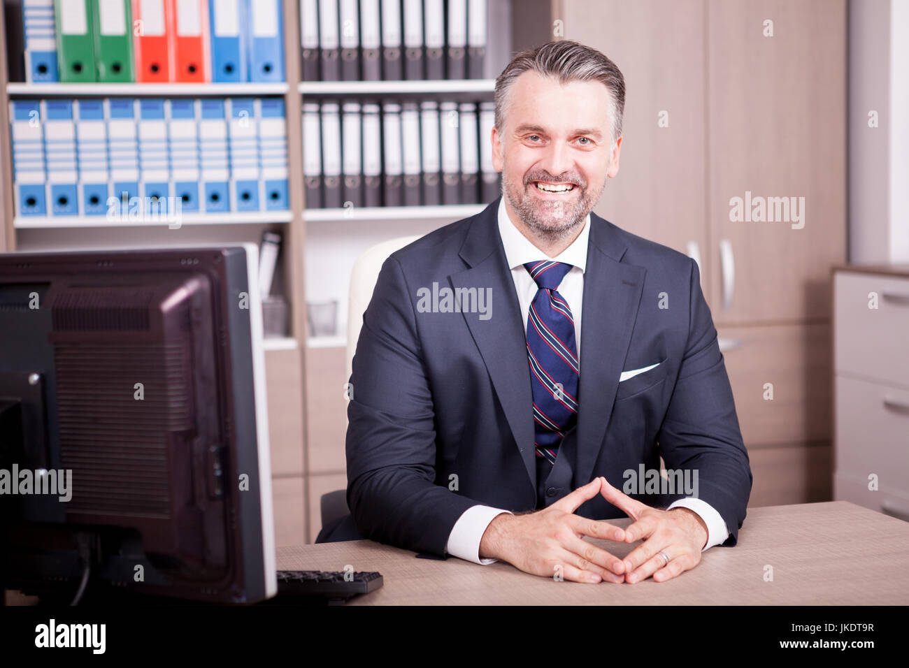 Smiling adult CEO at his desk in office Stock Photo - Alamy
