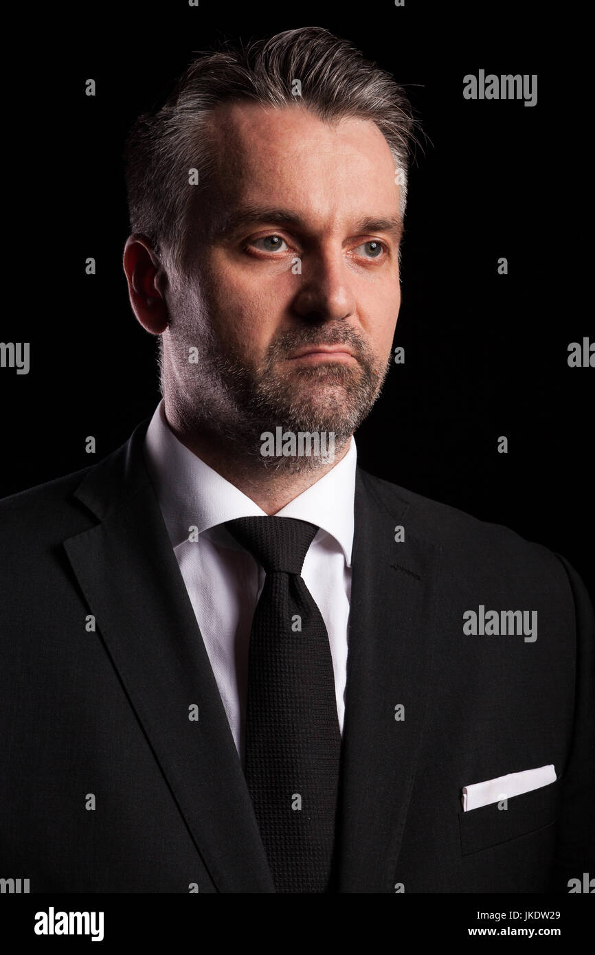 Dramatic portrait of businessman on black background Stock Photo - Alamy