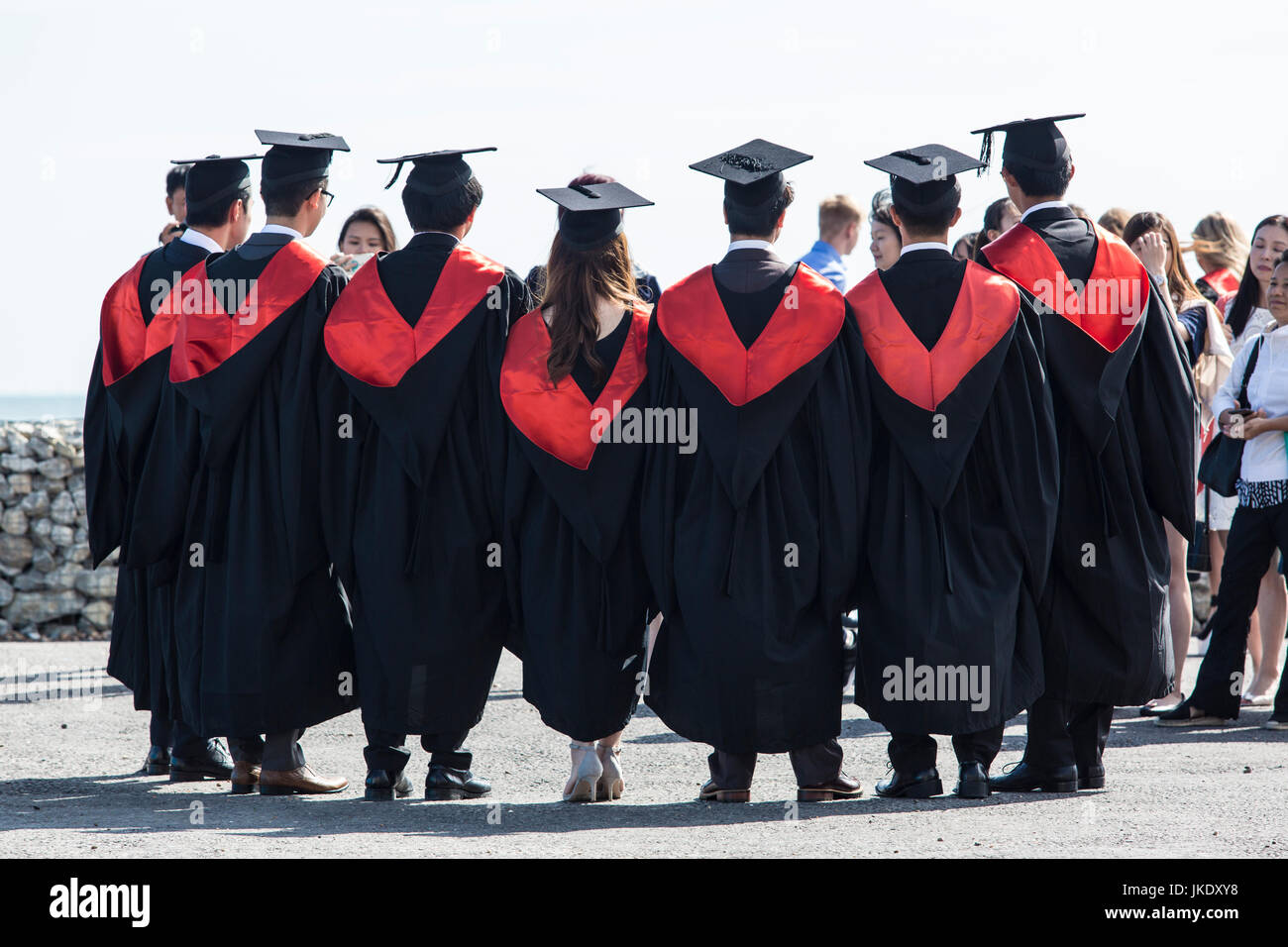 A group of new graduates having their photographs taken by family ...