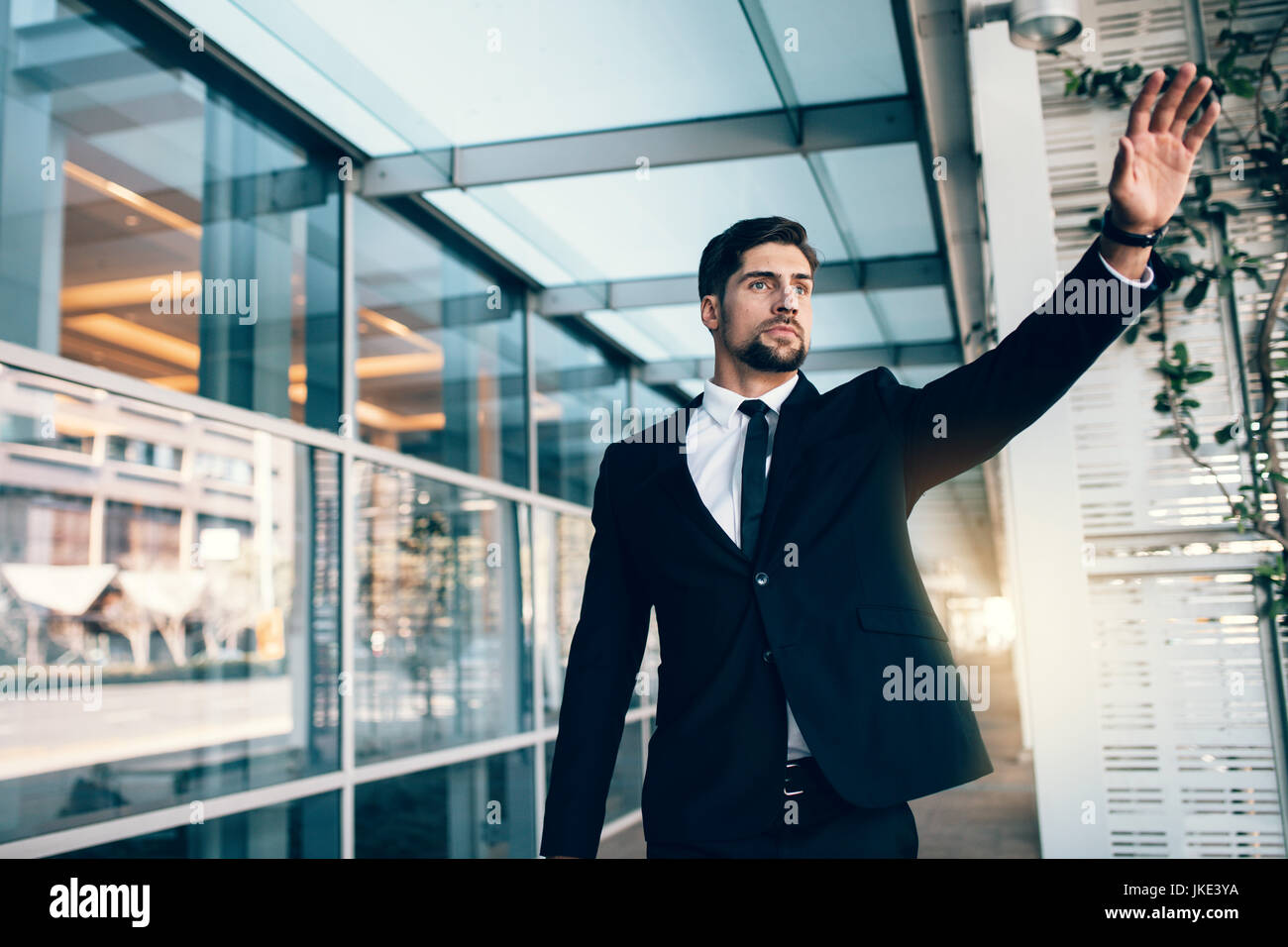 Young businessman calling taxi after arriving from trip. Young ...