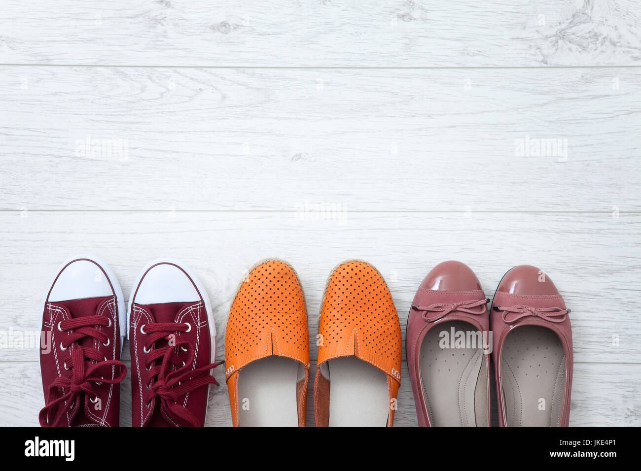 Flat lay fashion set: colored slippers shoes on white wooden background ...