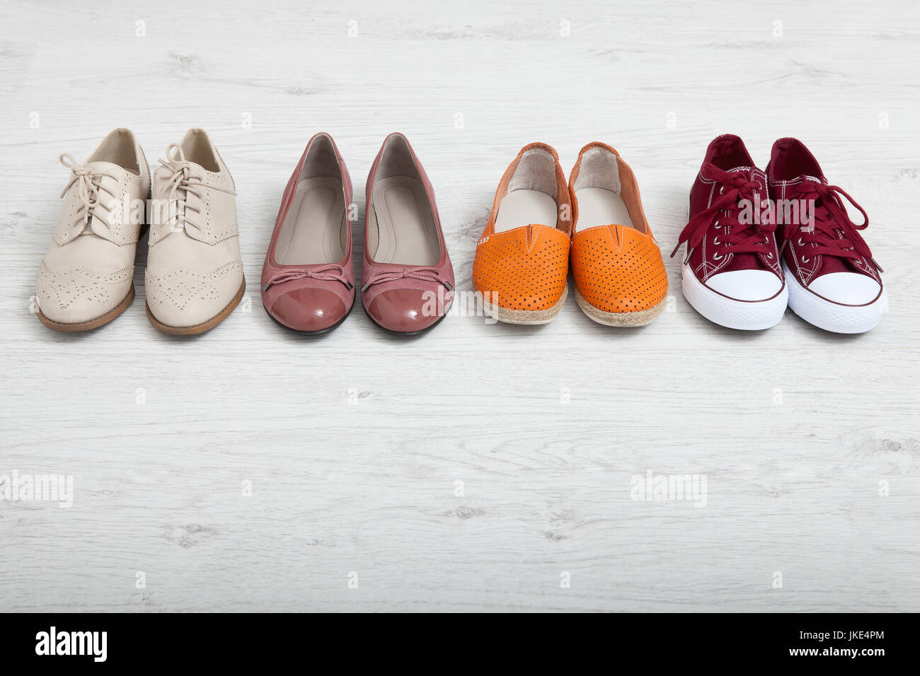 Flat lay fashion set: colored slippers shoes on white wooden background ...