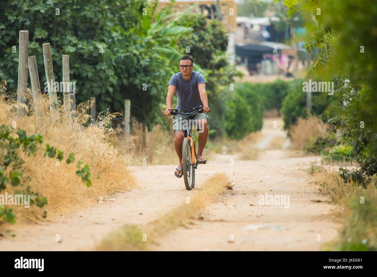 Portrait of happy guy riding bicycle in the park Stock Photo - Alamy