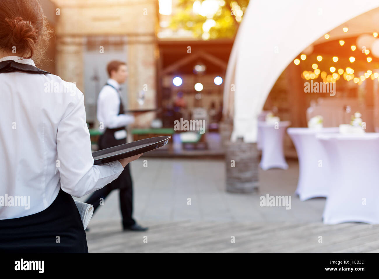 Waiter holding an empty tray in outdoor cafe. Catering service Stock ...