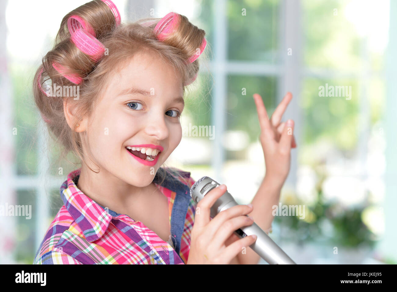 Portrait of adorable little girl singing karaoke Stock Photo - Alamy