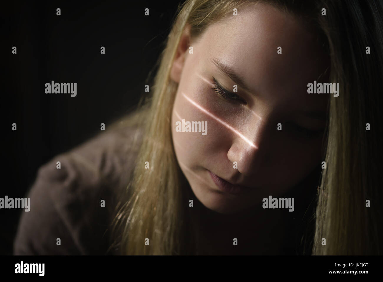 closeup shot of teen girl looking at smartphone screen in sunset light ...