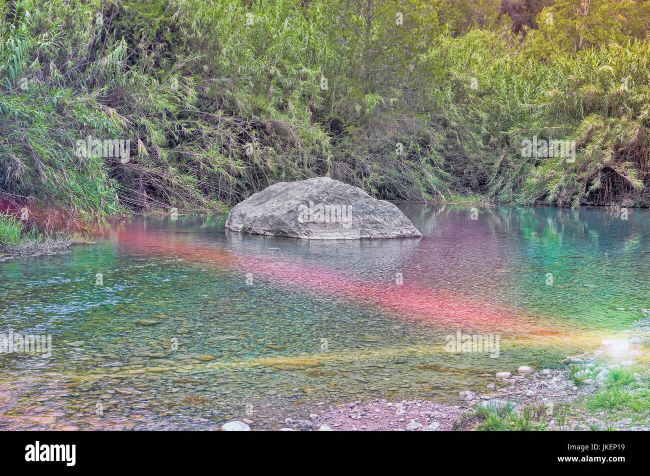 Mijares river with clear waters and big rock in the middle. Thermal ...