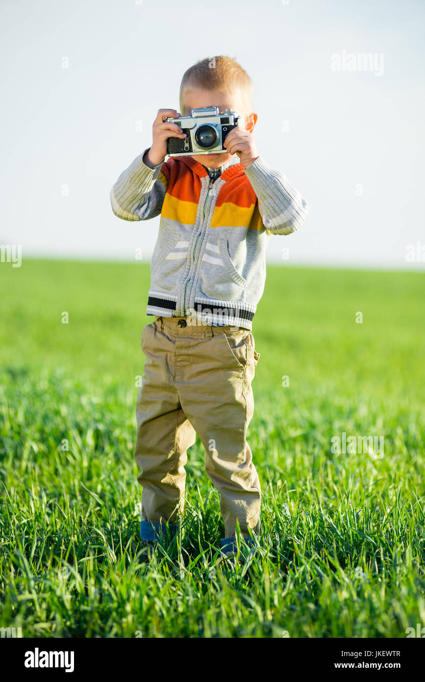 Little boy with an old camera shooting outdoor. Kid taking a photo ...