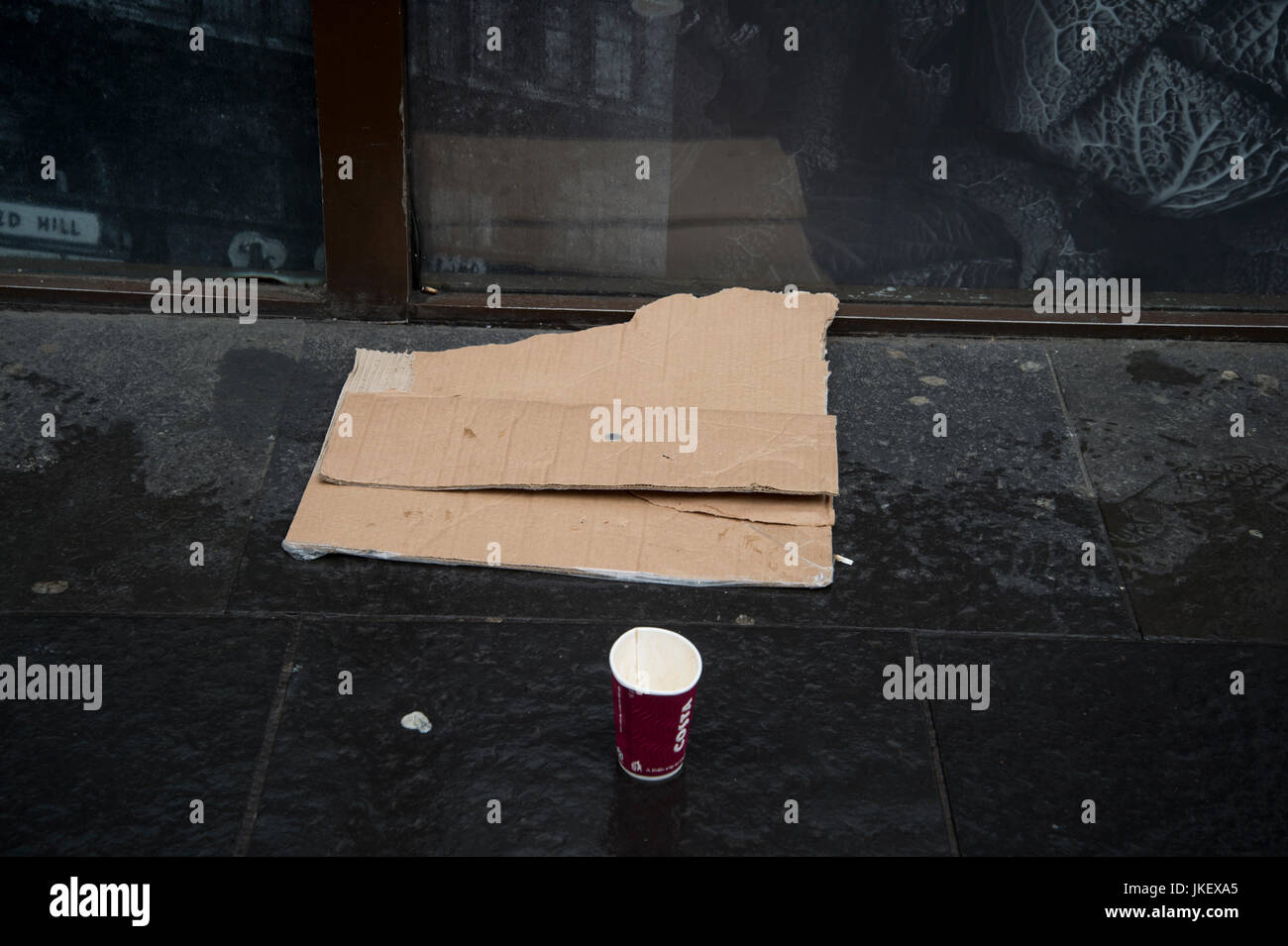 Scotland. Glasgow. Cardboard marking the pitch of a beggar, in front of ...