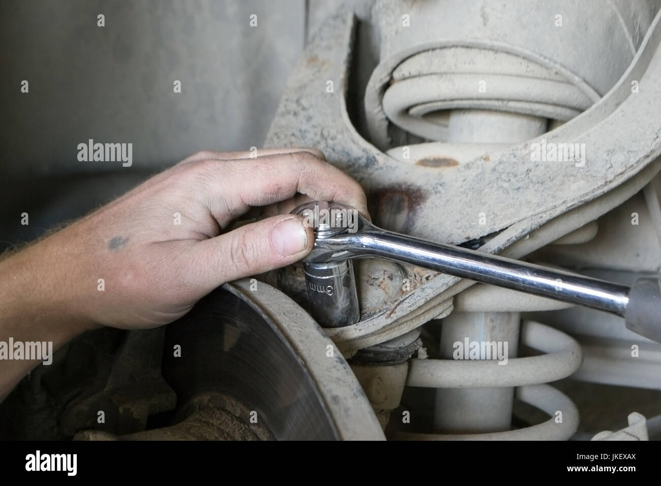 A professional mechanic repairs the car. Tighten the bolt Stock Photo ...