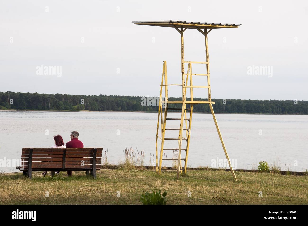 a couple watching the lake sitting on the bench Stock Photo - Alamy
