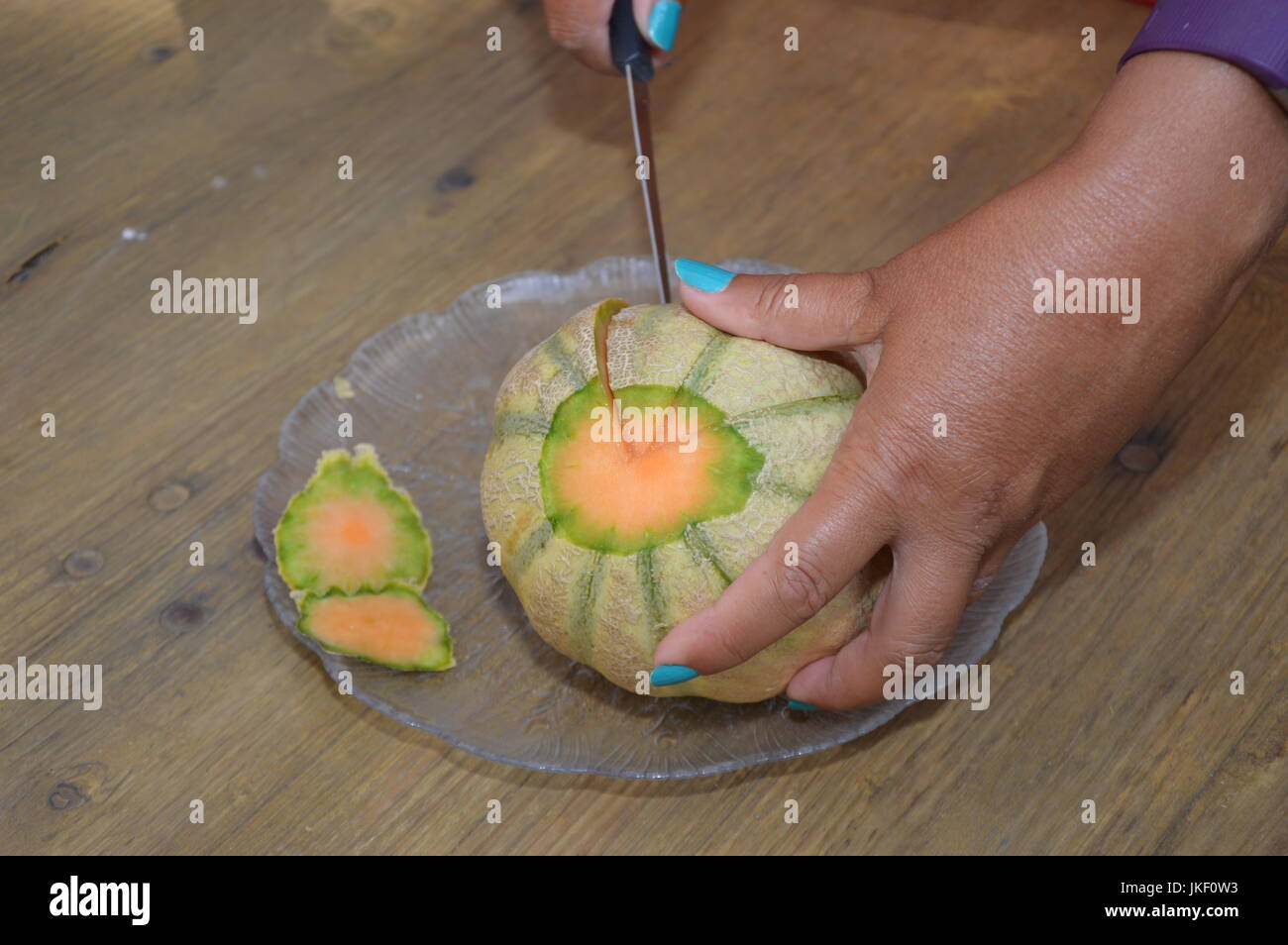 A Woman cut a melon Stock Photo - Alamy