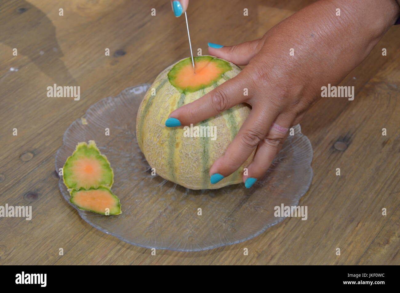 A Woman cut a melon Stock Photo - Alamy