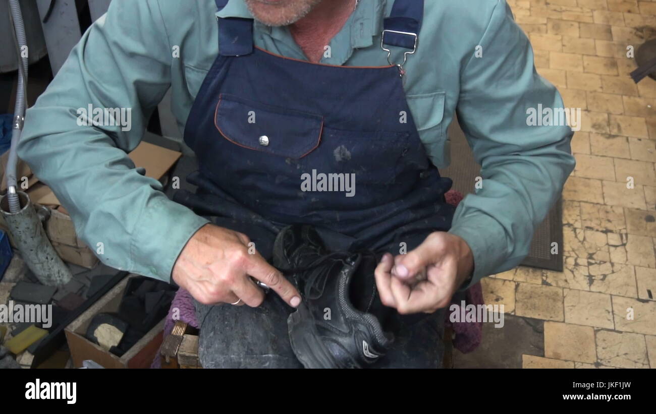 the shoemaker at work.The process of repairing shoes in workshop Stock ...