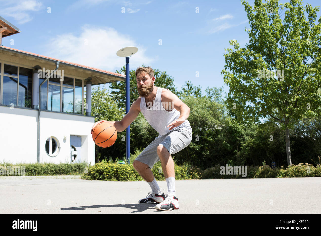 Man playing basketball on outdoor court Stock Photo - Alamy