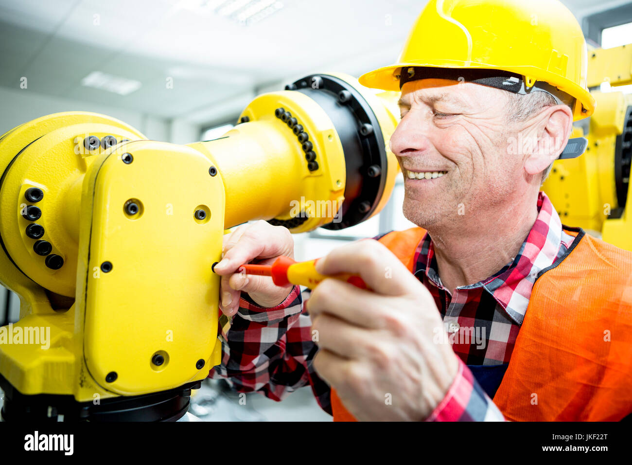 Smiling technician working on industrial robot Stock Photo - Alamy