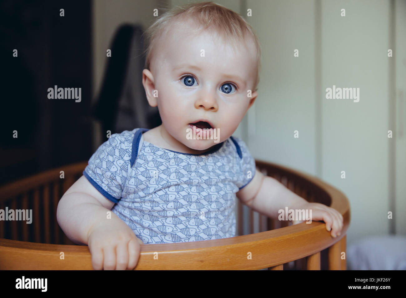Portrait of baby boy standing in his crib Stock Photo - Alamy