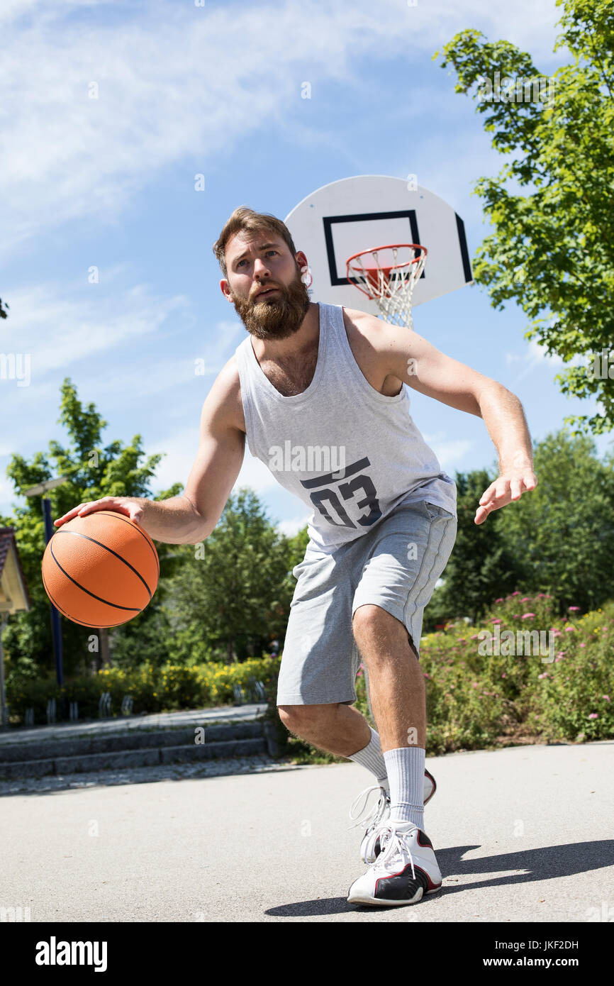 Man playing basketball on outdoor court Stock Photo - Alamy