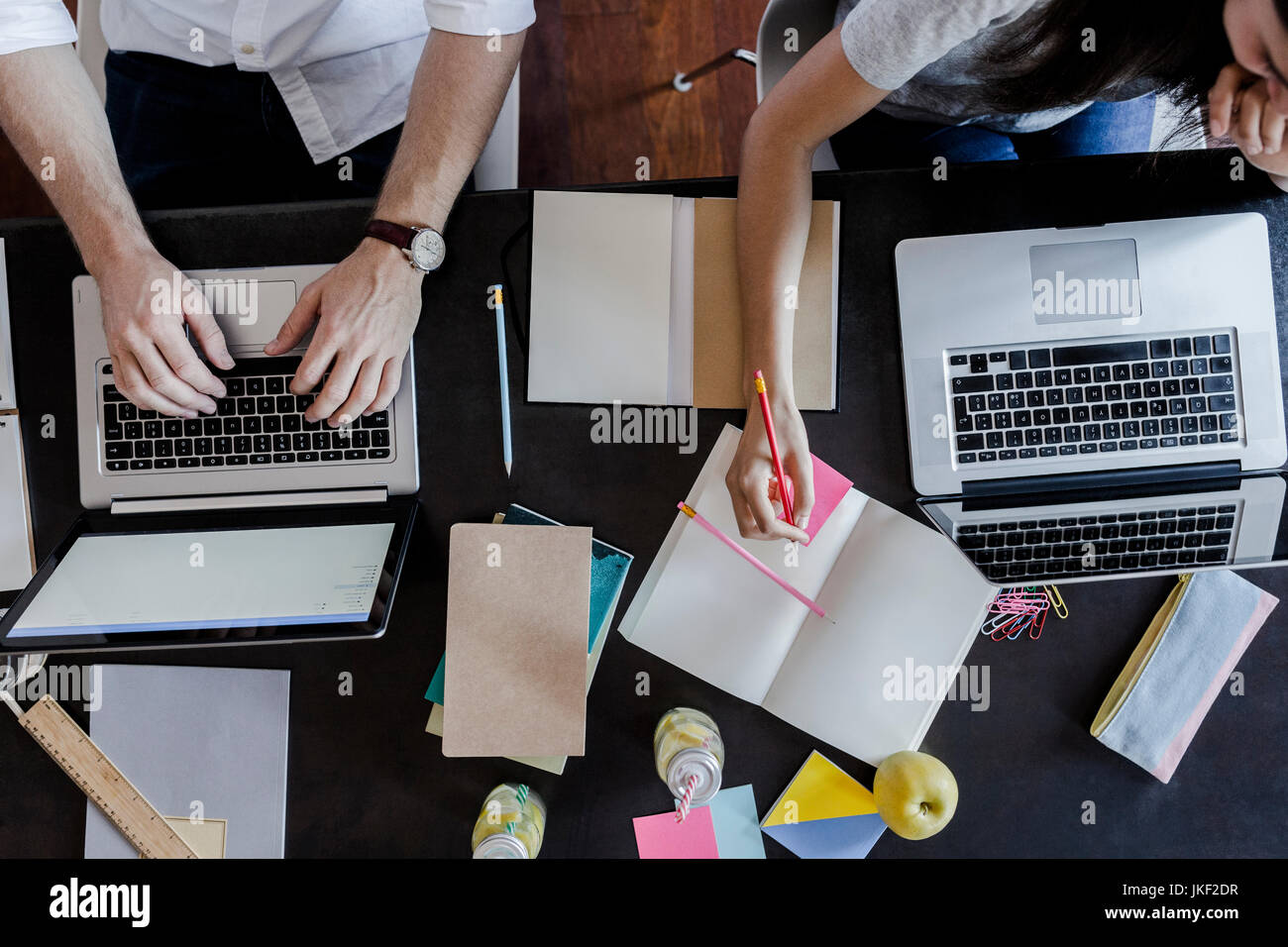 Top view of man and woman using laptops and taking notes Stock Photo ...