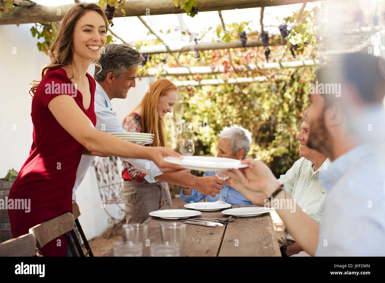 Happy family setting table outside for lunch Stock Photo - Alamy