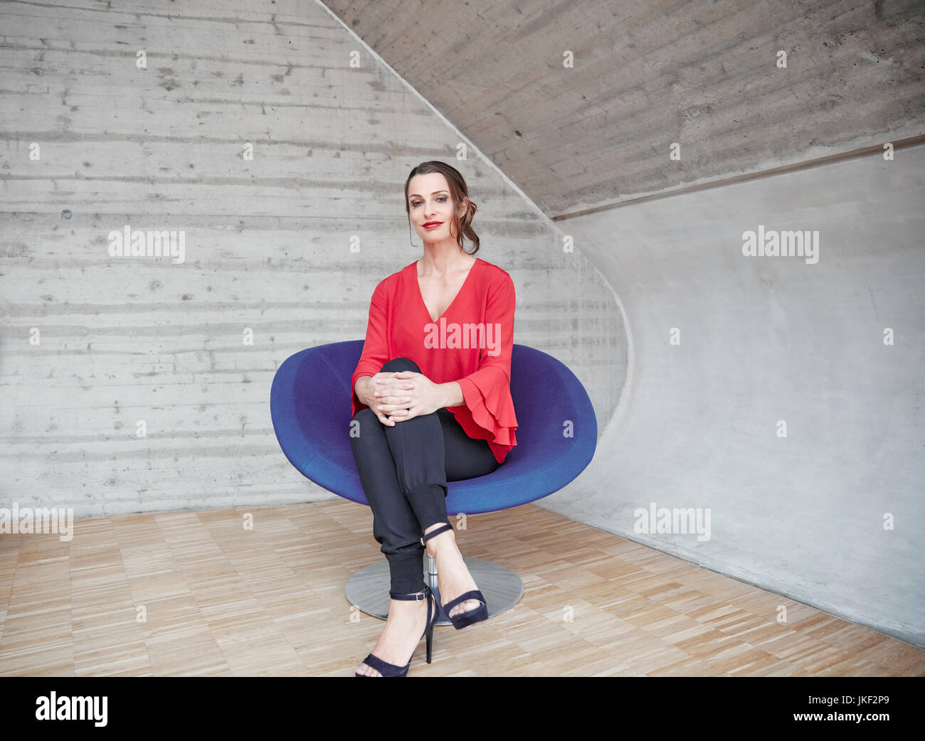 Confident woman sitting in chair Stock Photo - Alamy