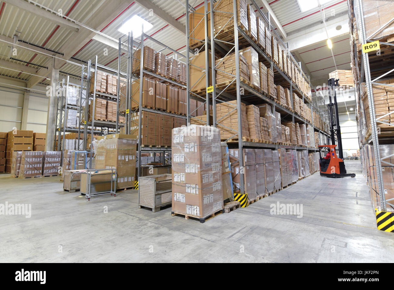 Forklift in high rack warehouse Stock Photo - Alamy