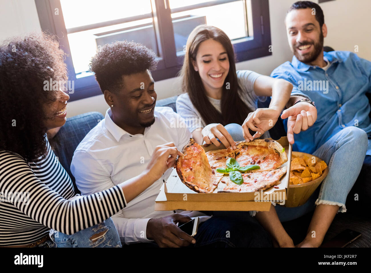 Four friends sharing pizza hi-res stock photography and images - Alamy