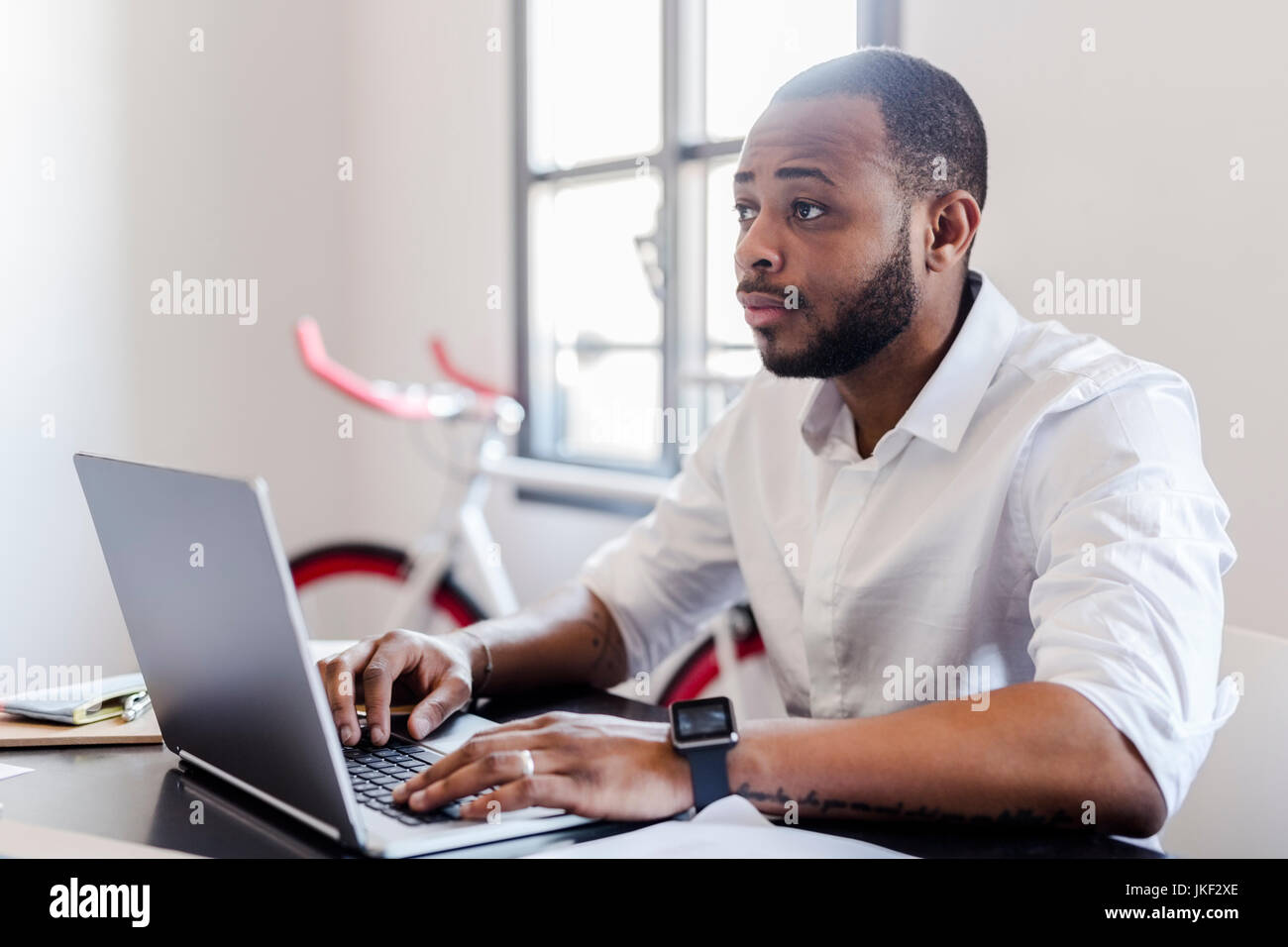 Man using laptop at desk in home office Stock Photo - Alamy