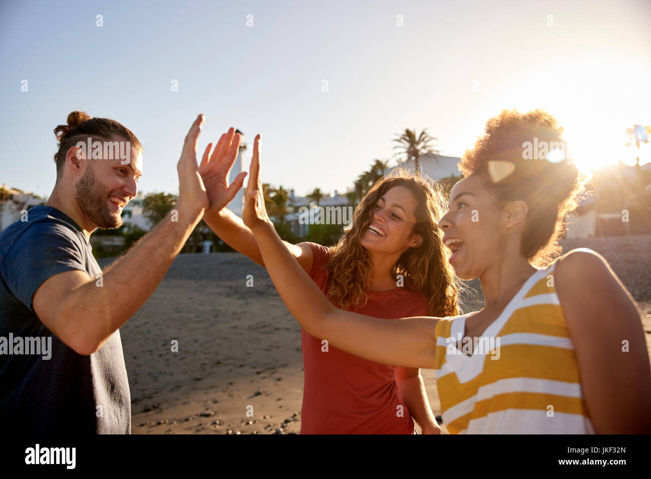 Three friends High Fiving on the beach Stock Photo - Alamy