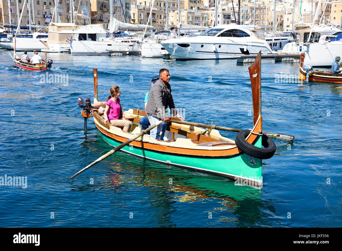 Passengers on board traditional Maltese Dghajsa water taxis in the ...