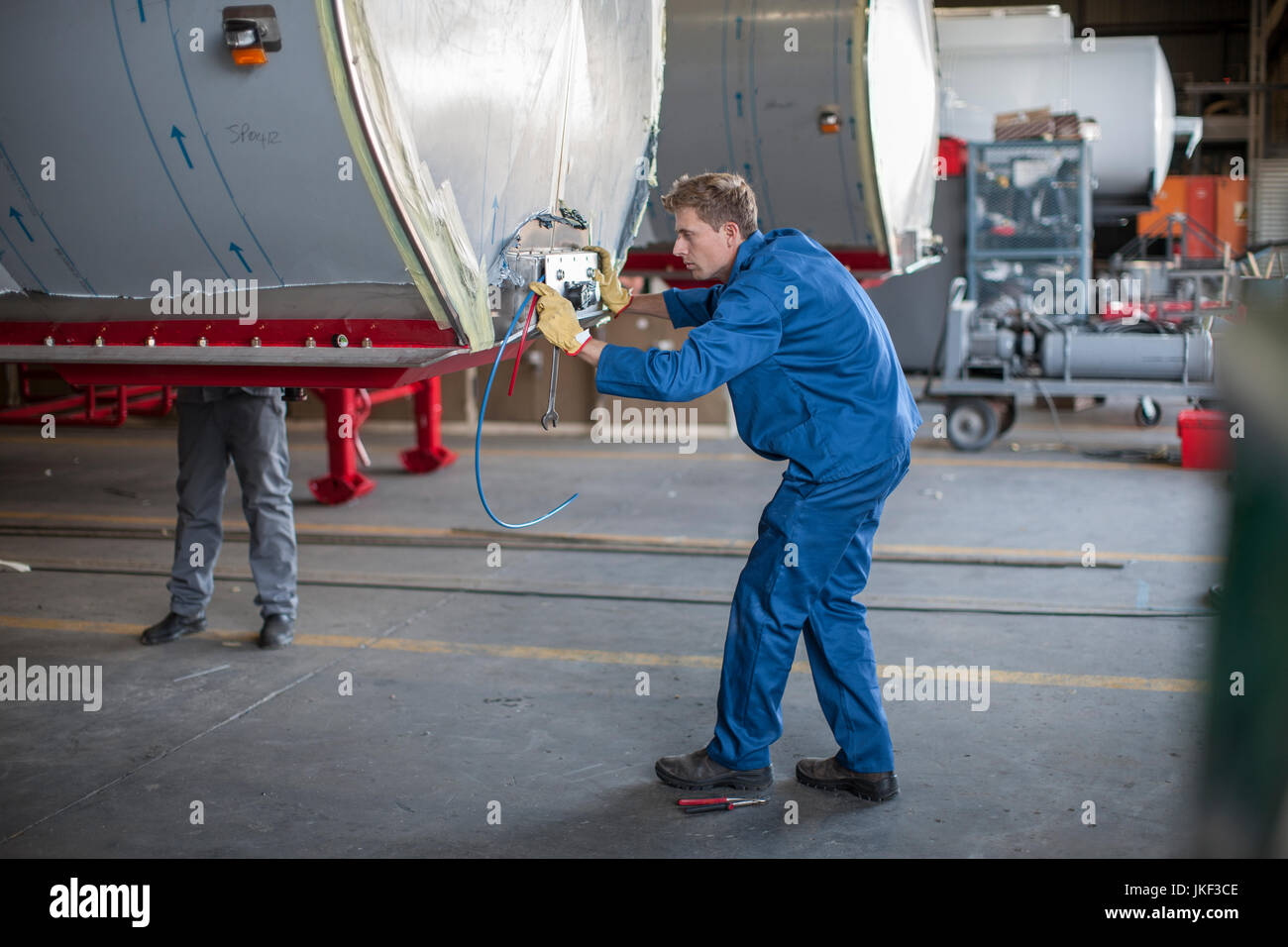 Industrial worker checking containers settings Stock Photo - Alamy