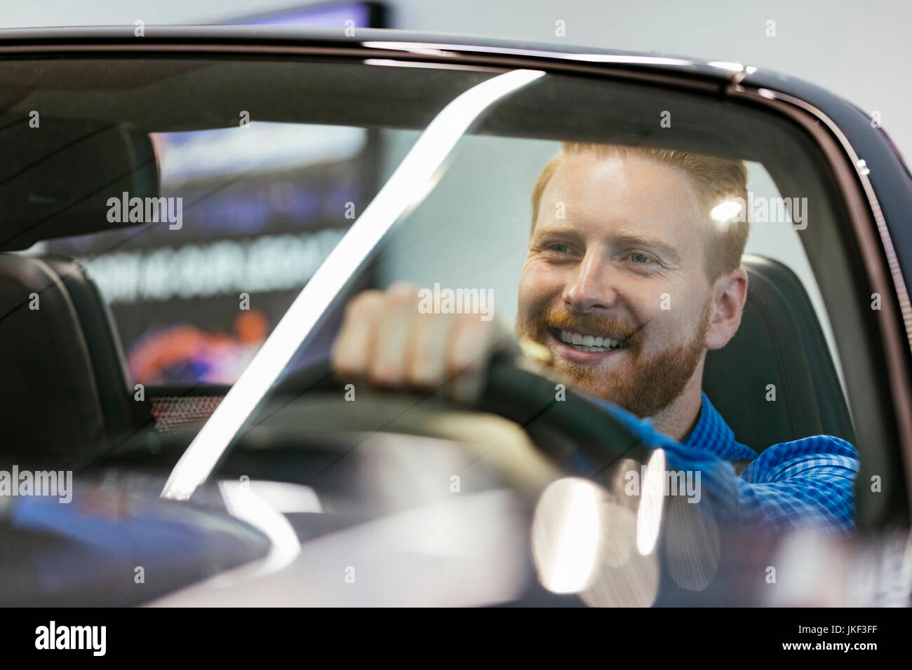 Young man testing car in car dealership Stock Photo - Alamy