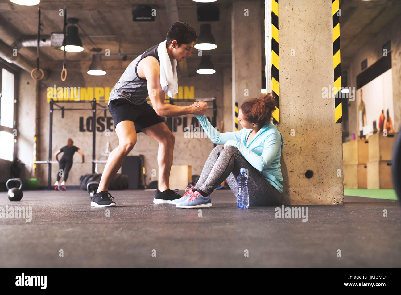 Woman helping friend in exercising hi-res stock photography and images ...