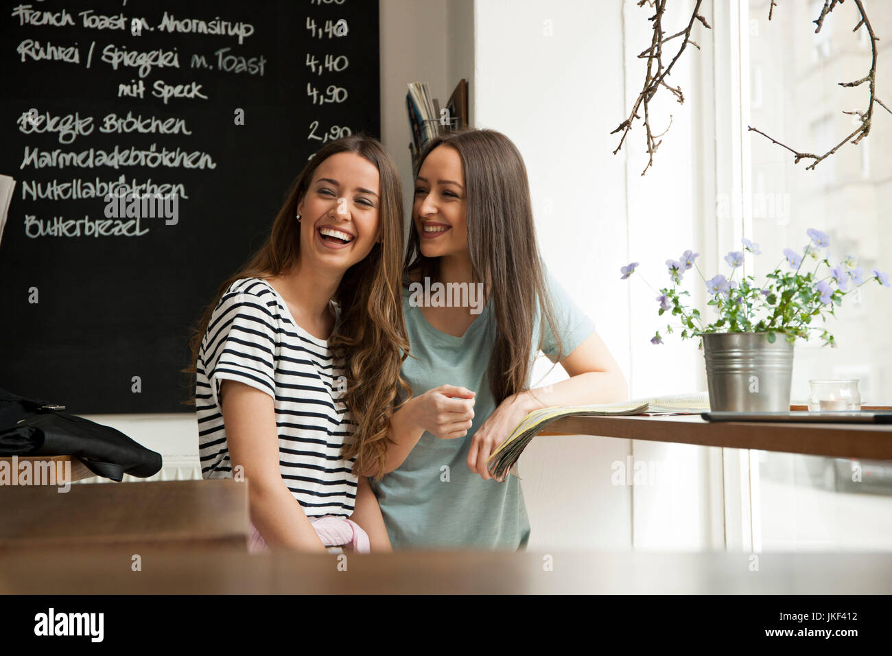 Girlfriends meeting in a cafe Stock Photo - Alamy