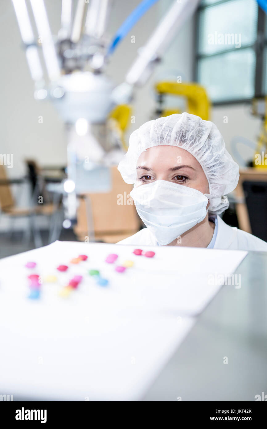 Woman watching robot handling sweets Stock Photo - Alamy