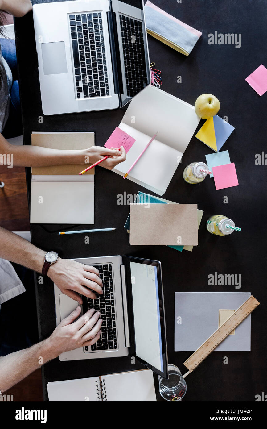 Top view of man and woman using laptops and taking notes Stock Photo ...