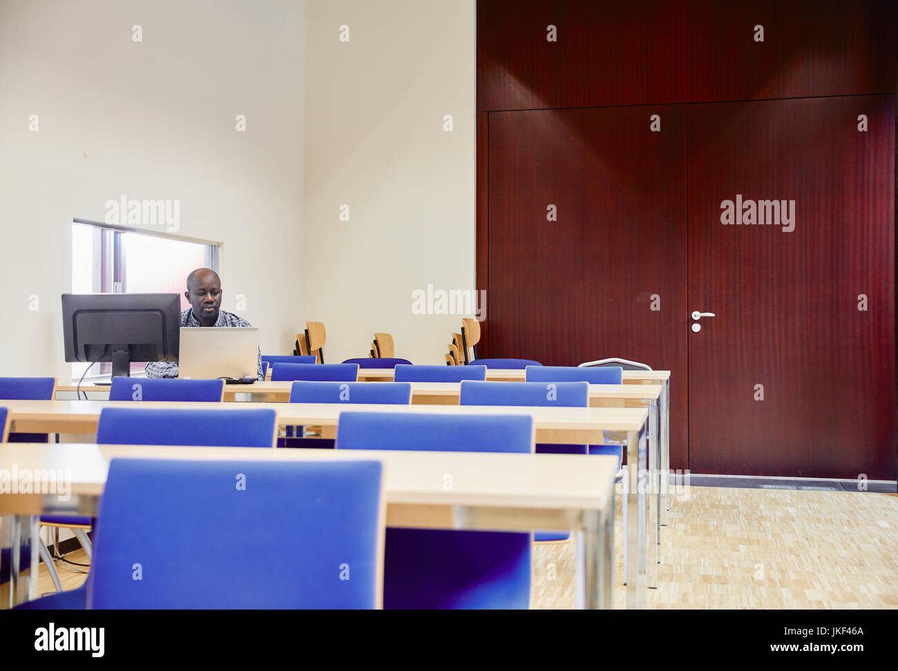 Man using computer in training room Stock Photo - Alamy