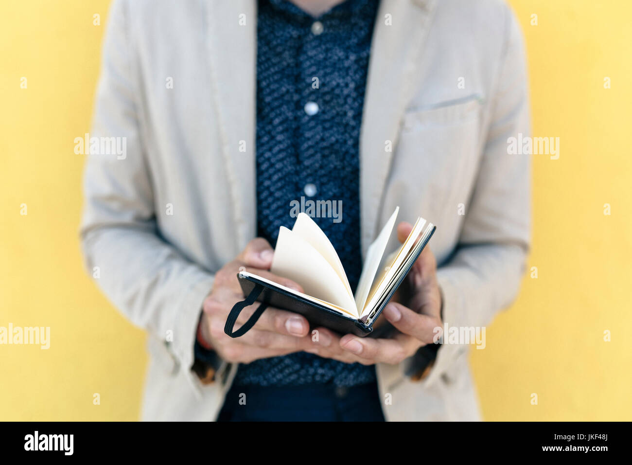 Man's hands holding note book, close-up Stock Photo - Alamy