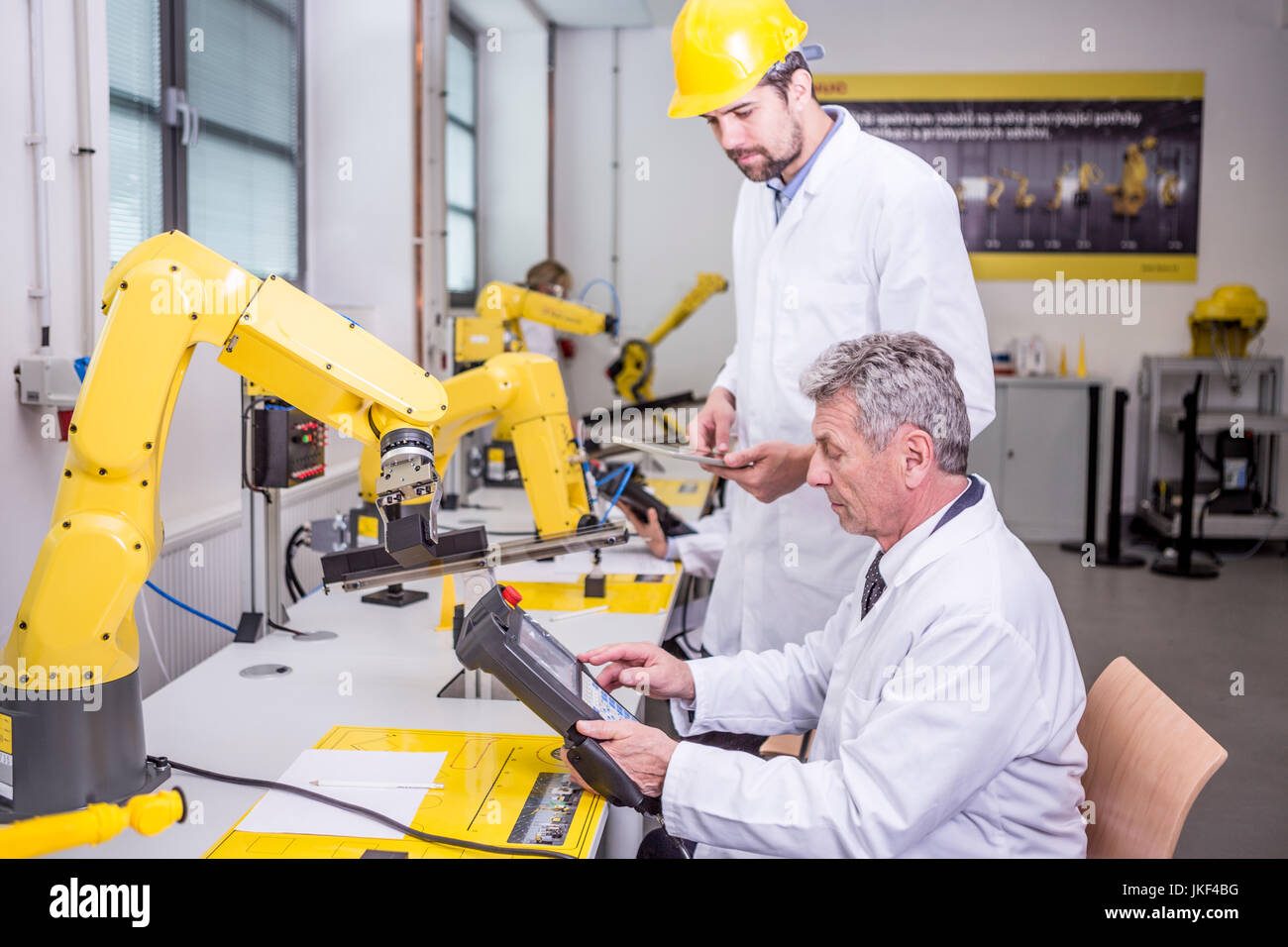 Two engineers in factory looking at device Stock Photo - Alamy