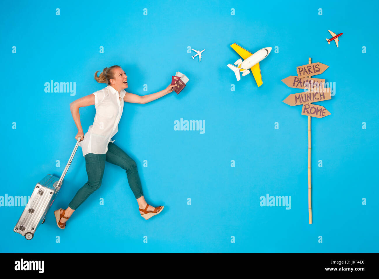 Woman with suitcase hurrying to to get her flight for a city break ...