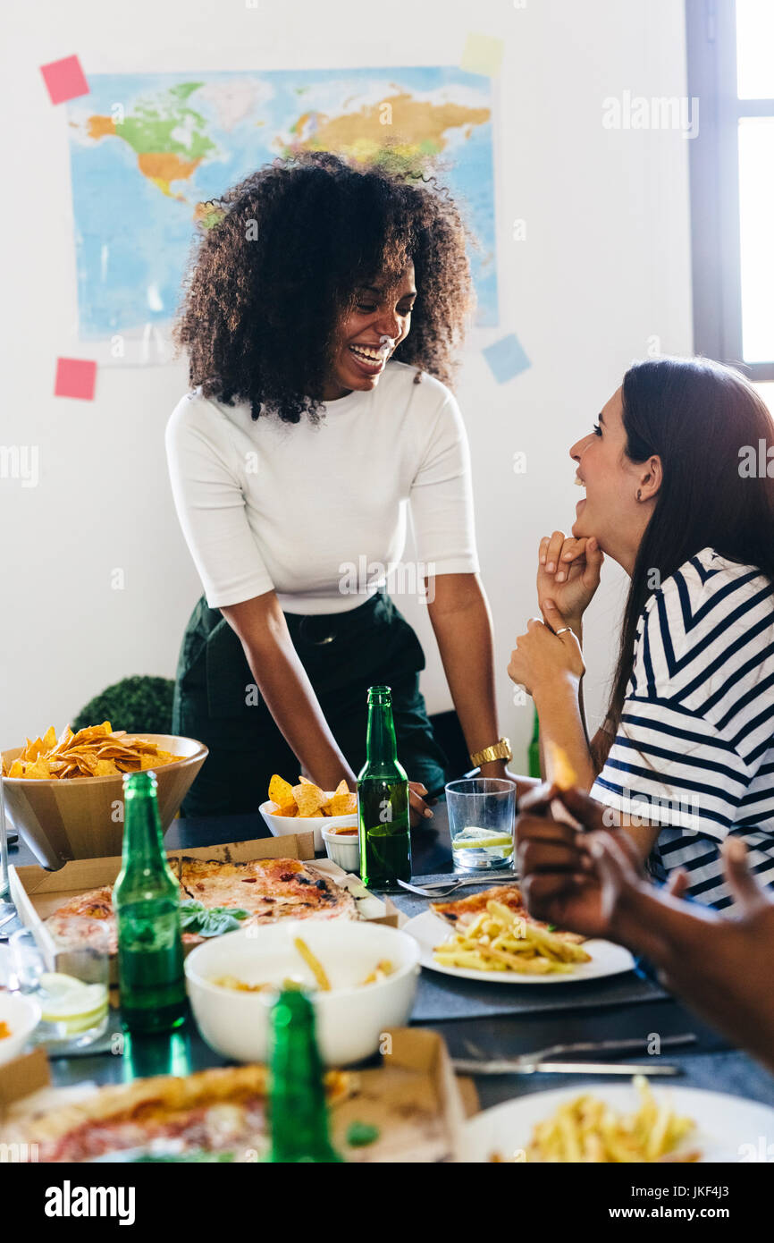 Two happy young women at dining table Stock Photo - Alamy